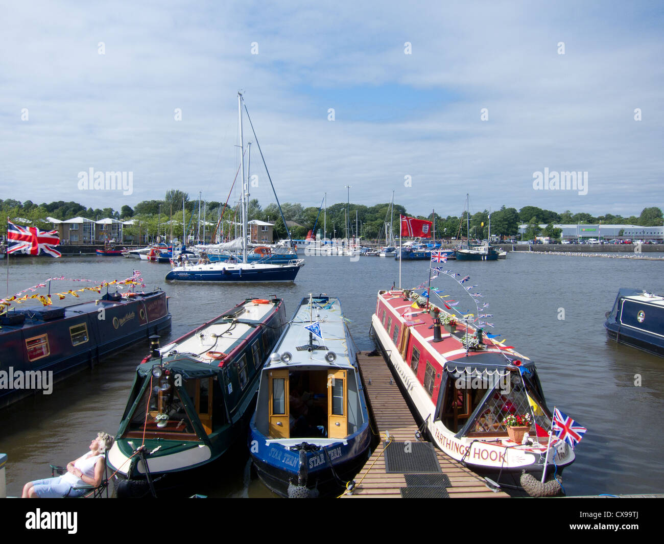 traditional british canal longboats moored in marina with yachts in ...