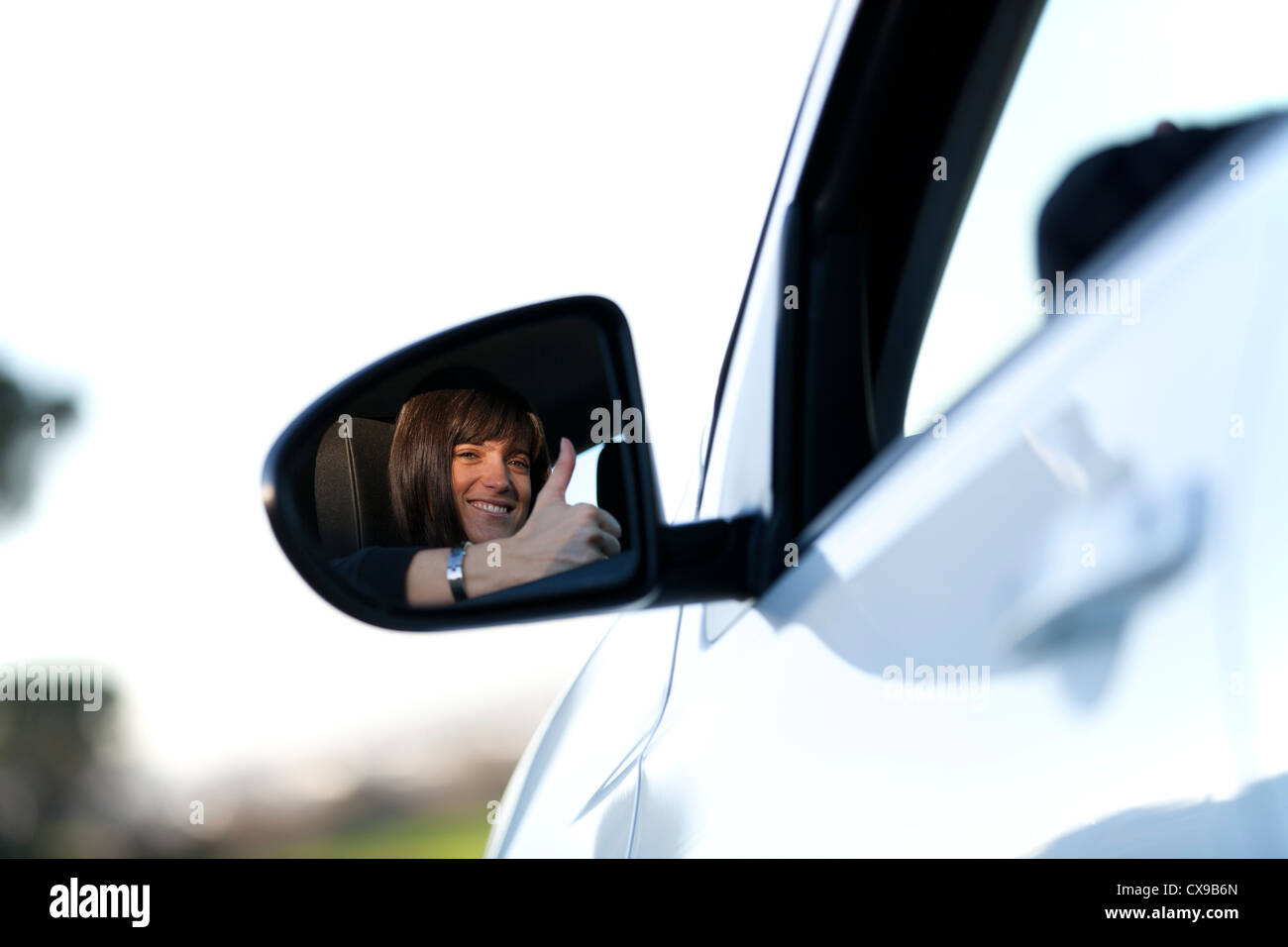Beautiful woman face reflected on the side mirror of her new car Stock ...