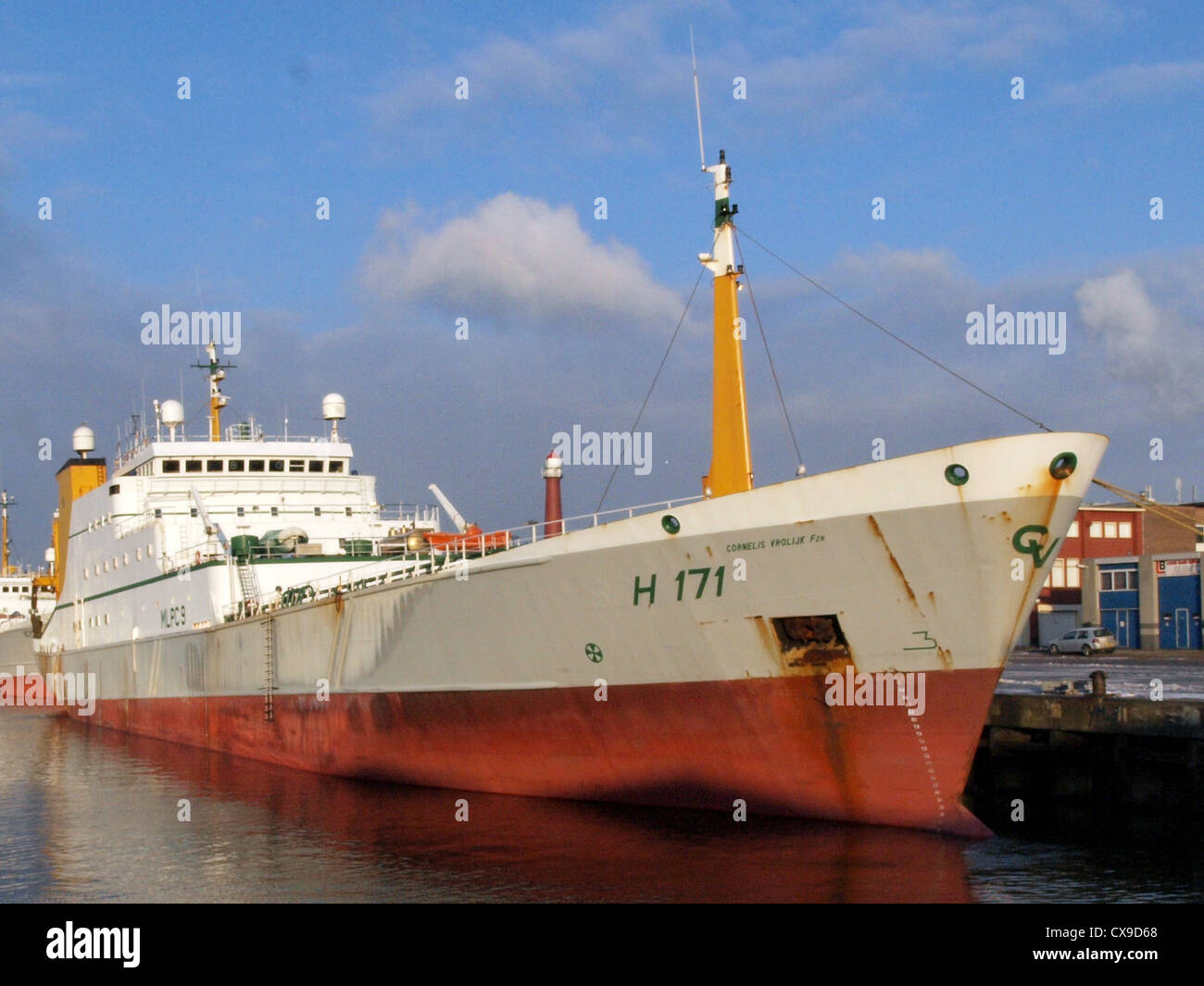 Fishing boats dock at port alongside cargo ships, demonstrating the ...