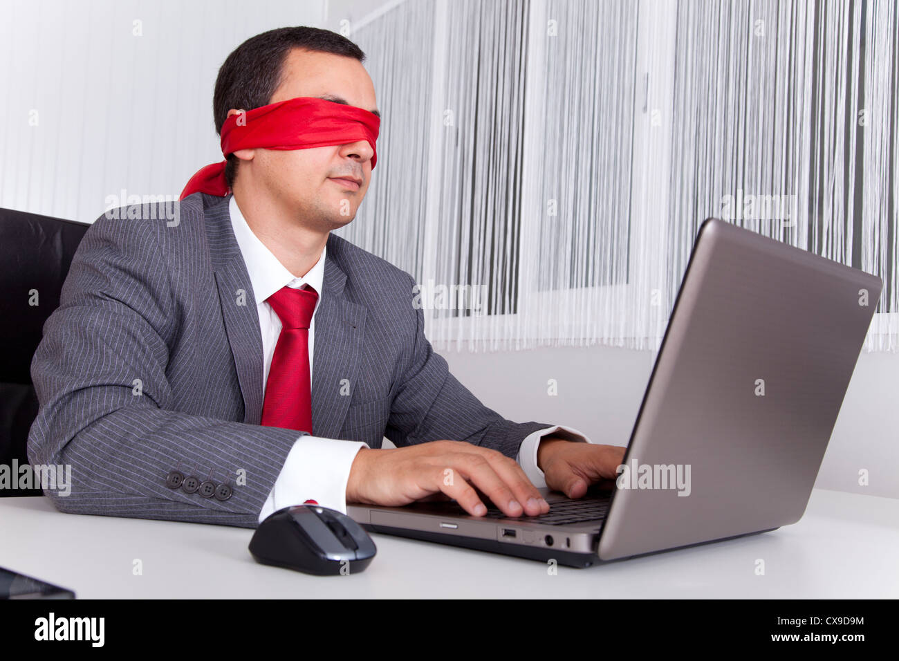 Blindfold businessman at the office working with his laptop Stock Photo ...