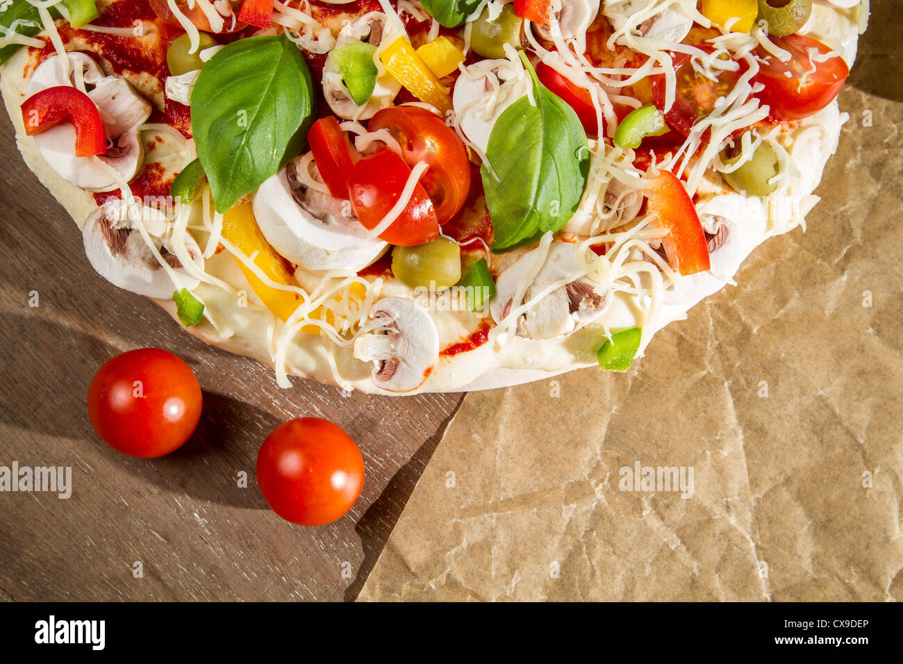 Close-up of fresh pizza on the baking paper Stock Photo - Alamy