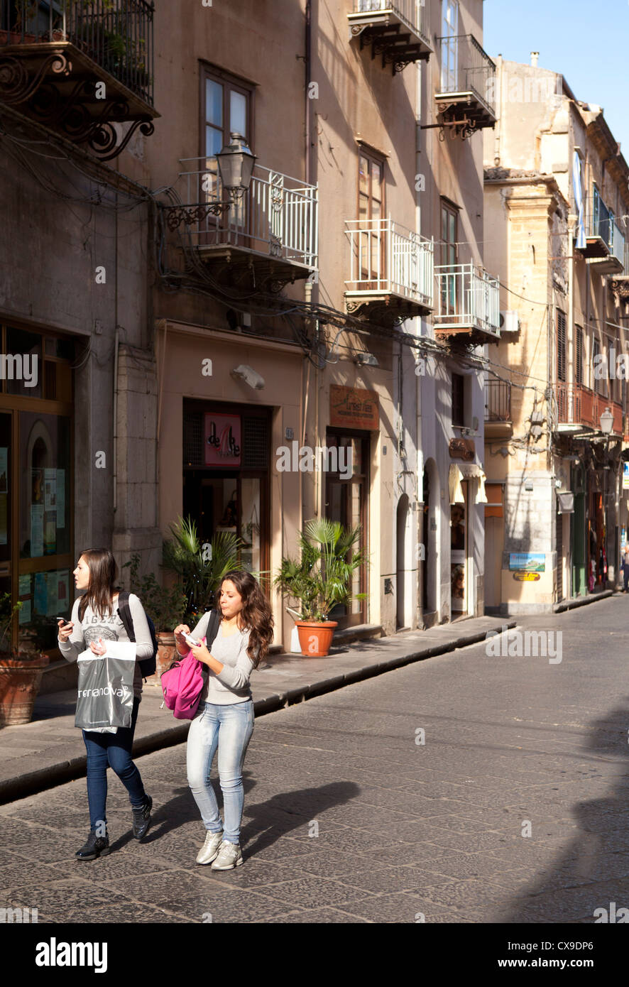 2 girls walking down street Cefalu Sicily Italy Stock Photo - Alamy