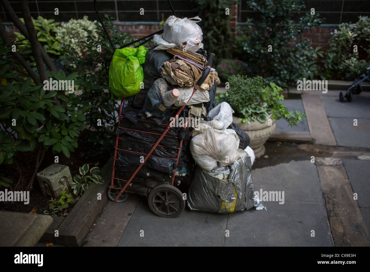 A homeless man's belongings is parked in a church outdoor area in New ...