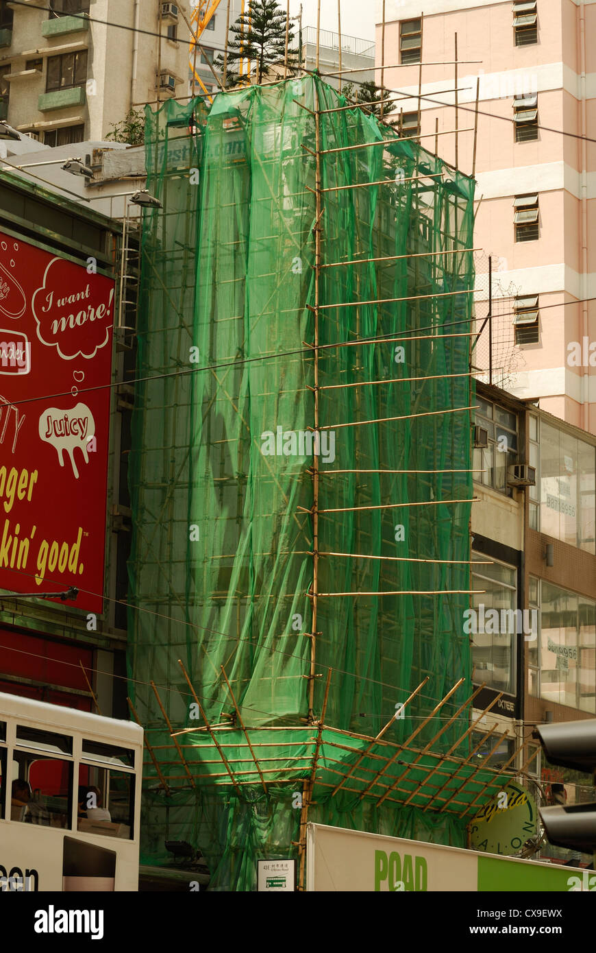 Bamboo scaffolding draped in netting enclose this Hong Kong building ...