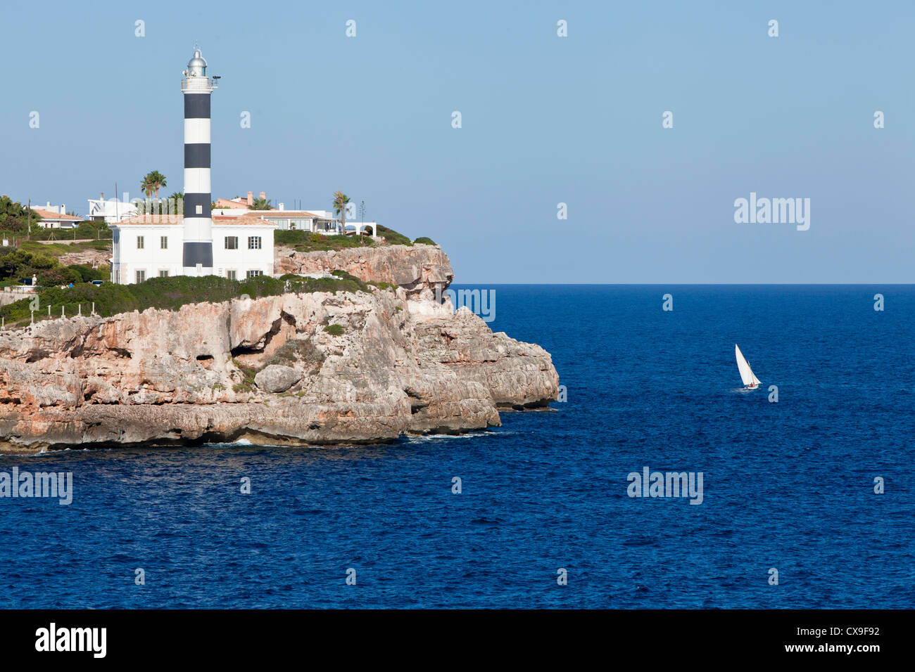 white lighthouse on rocks in the sea ocean water sky blue summer Stock ...