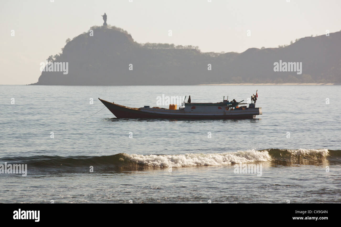Fishing boat and the large statue of Jesus, Dili, East Timor Stock ...