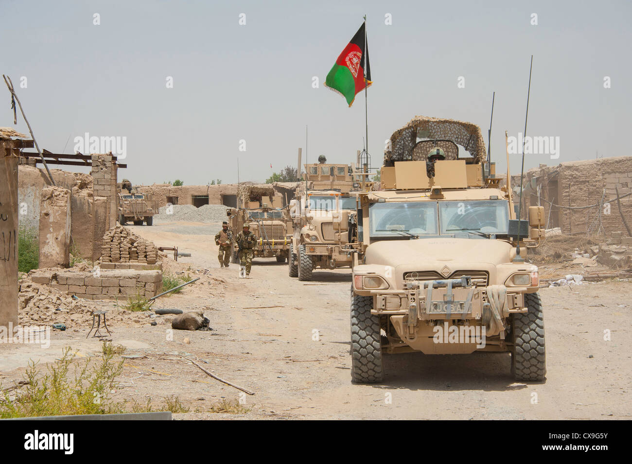 ISAF vehicles enter a war-damaged community in Helmand province ...