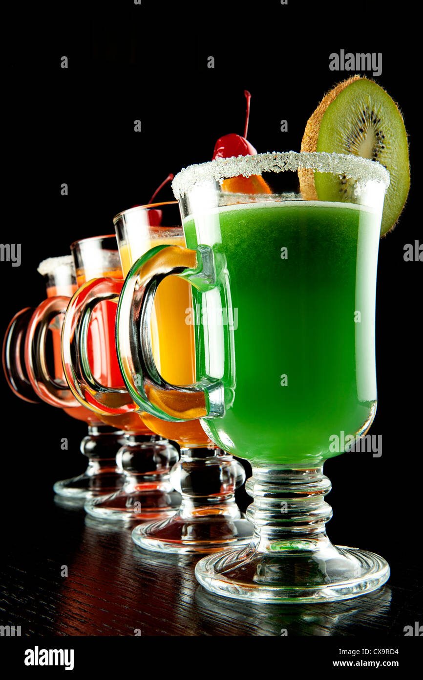 Group of four wine glasses with colored alcoholic cocktails, decorated ...