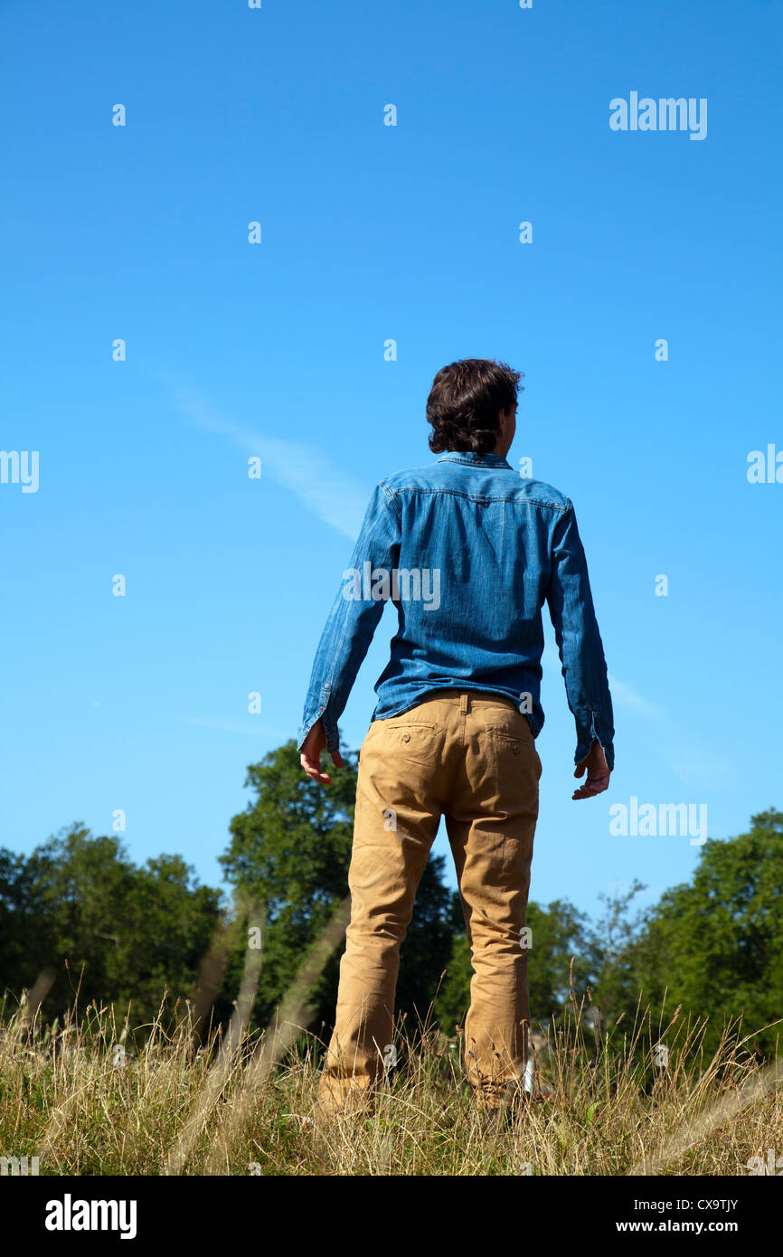 Man standing in Field Looking Out Stock Photo - Alamy