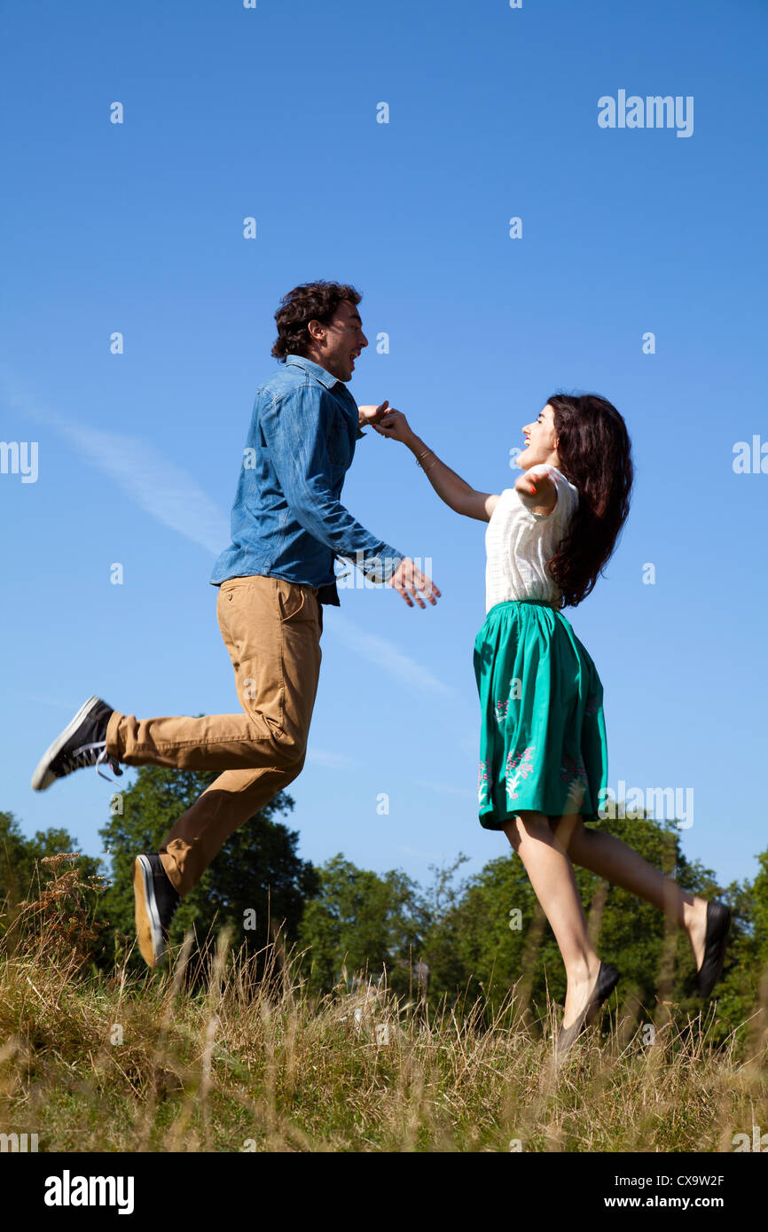 Romantic Couple Jumping in Park Stock Photo - Alamy