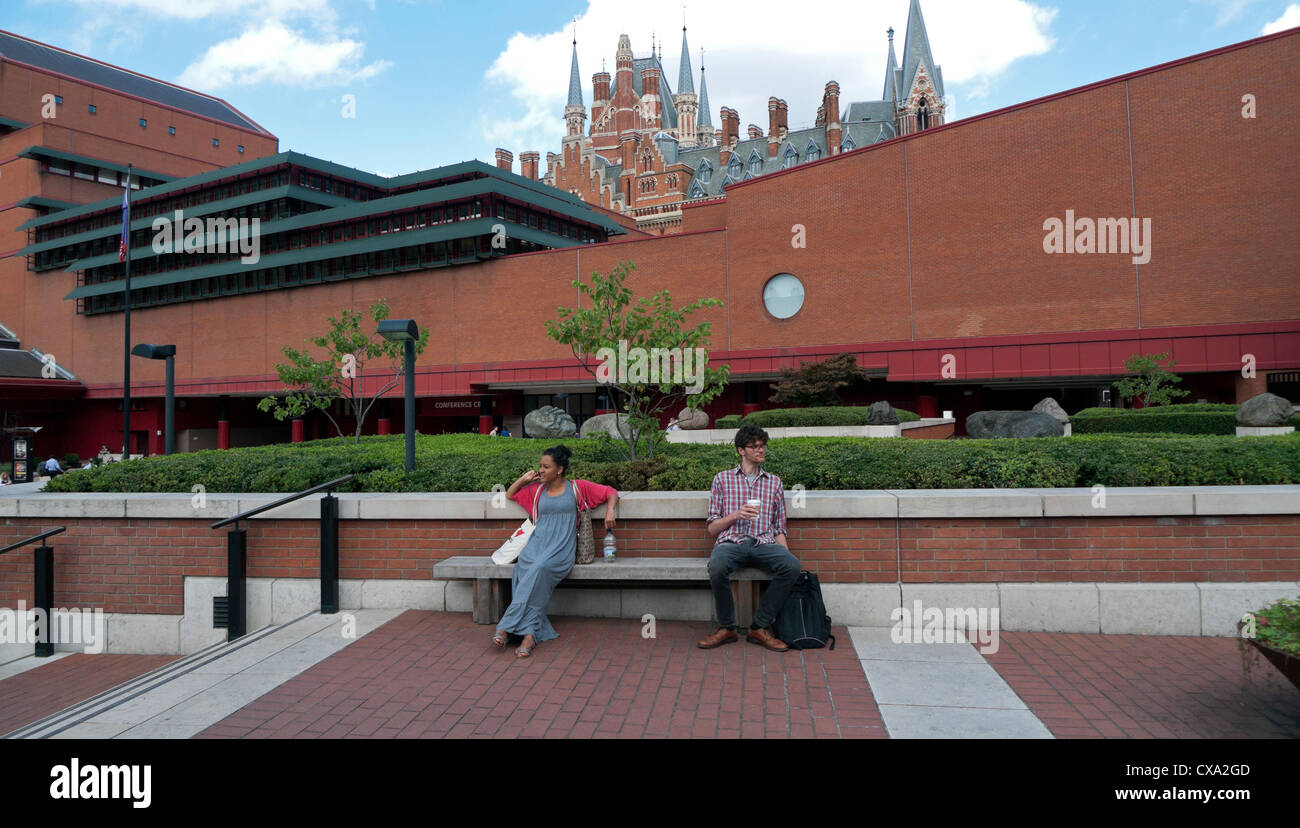 A man and woman sitting on a bench outside the British Library with St ...