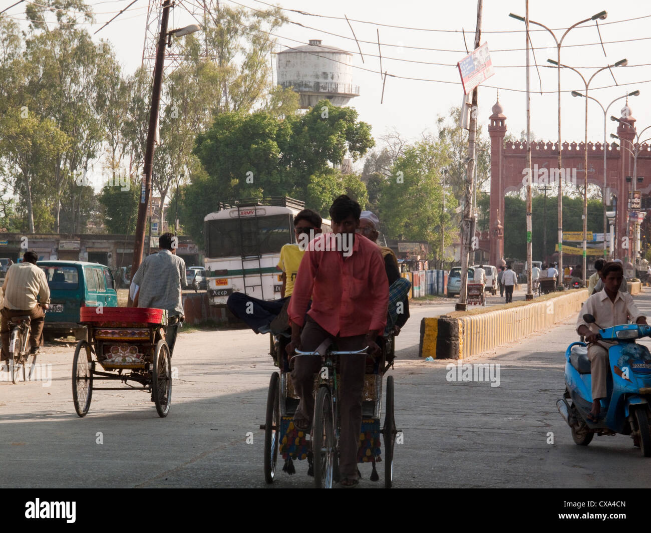 Man plying a manual rickshaw on a small town street in India. In the ...