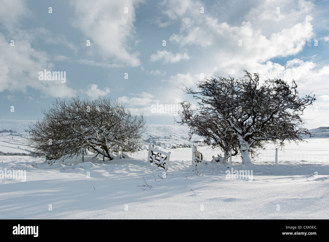 Winter view of snow covered moors, looking through an open gate and ...