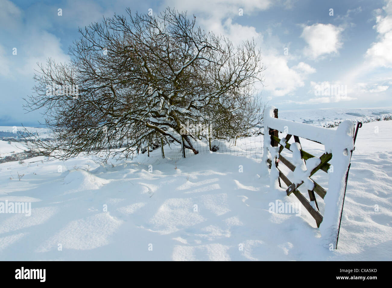 Winter view of snow covered moors, looking through an open gate and ...