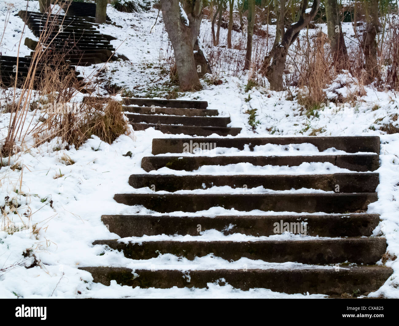 Snow covered steps in winter with ice and slippery surfaces causing a ...