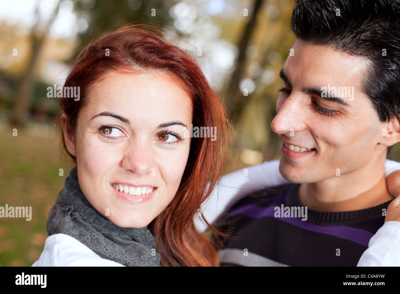 Love and affection between a young couple at the park in autumn season ...