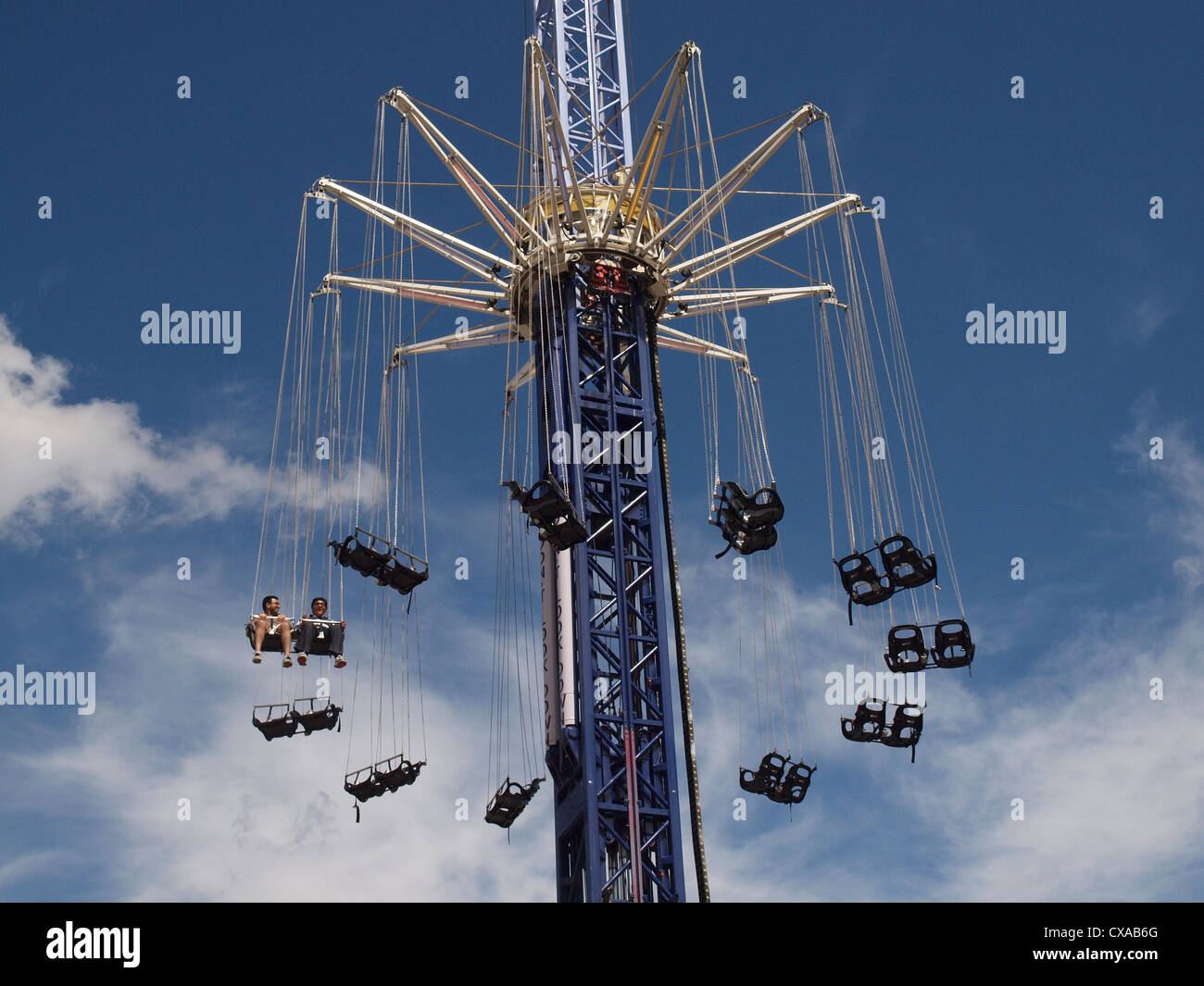 Towering roundabout ride at North Greenwich against a blue sky with ...