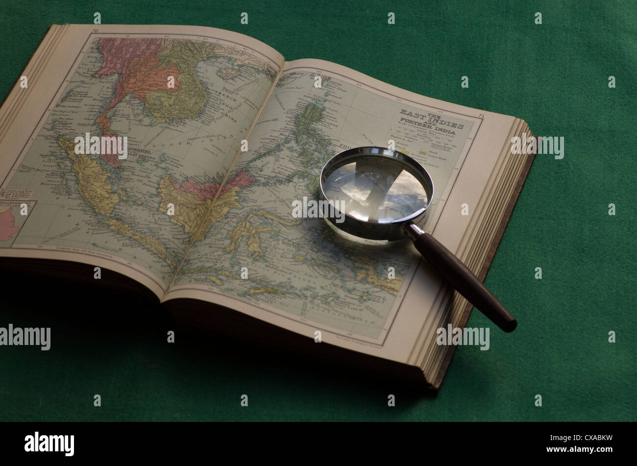 Old atlas with magnifying glass Stock Photo - Alamy