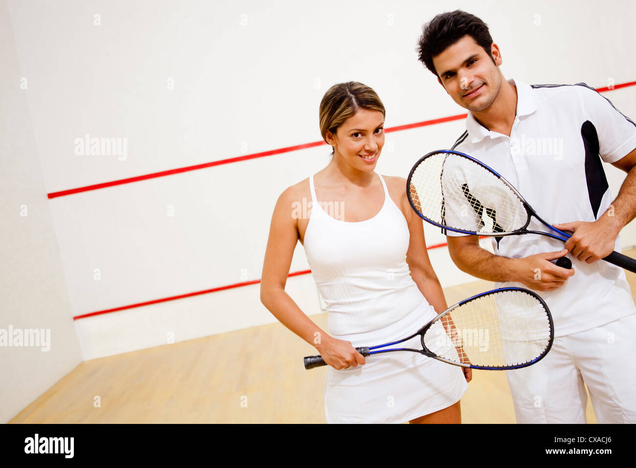 Hispanic couple holding squash racquets Stock Photo - Alamy