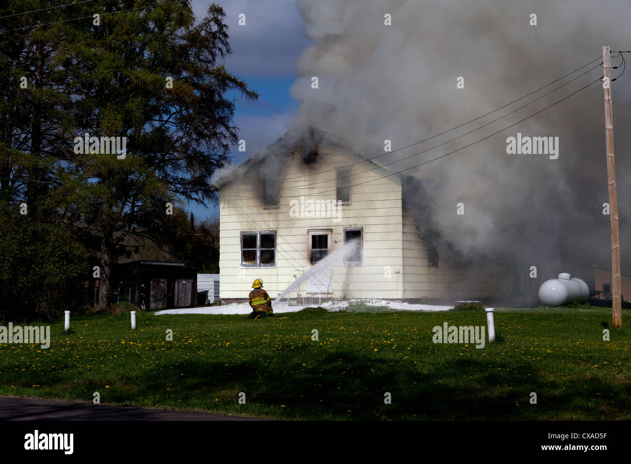 Volunteer firefighters fighting a house fire Stock Photo - Alamy