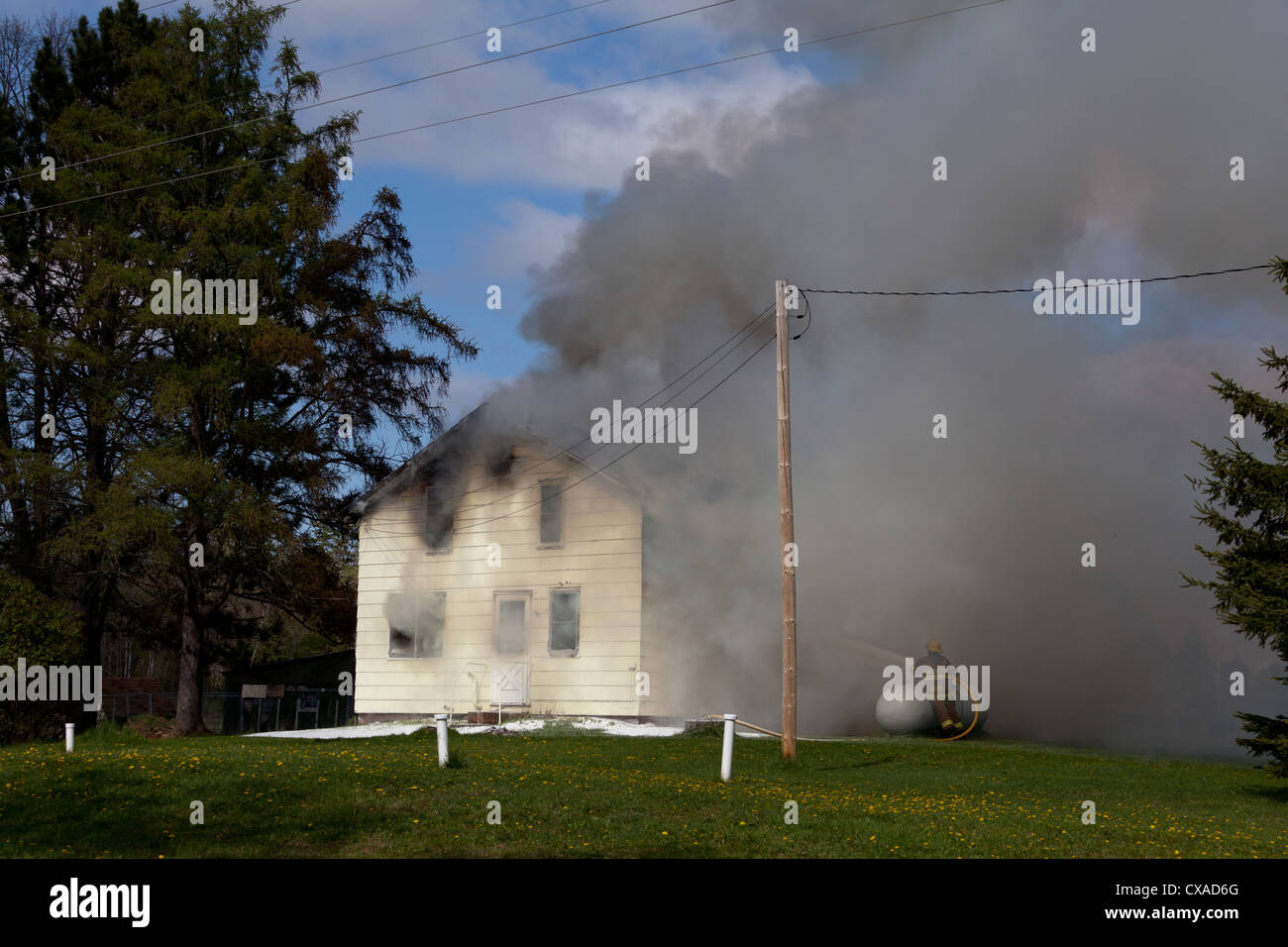 Volunteer firefighters fighting a house fire Stock Photo - Alamy