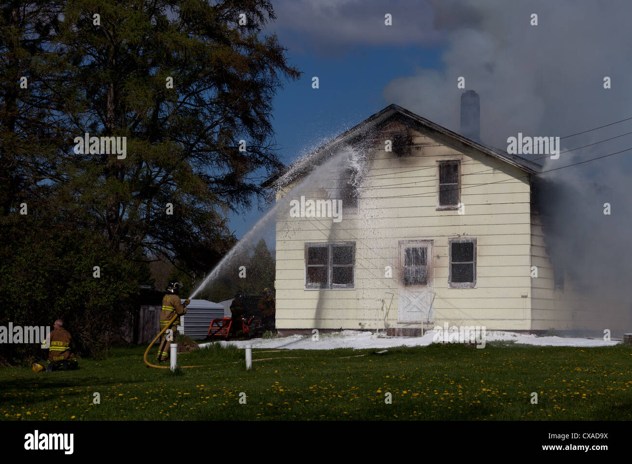 Volunteer firefighters fighting a house fire Stock Photo - Alamy