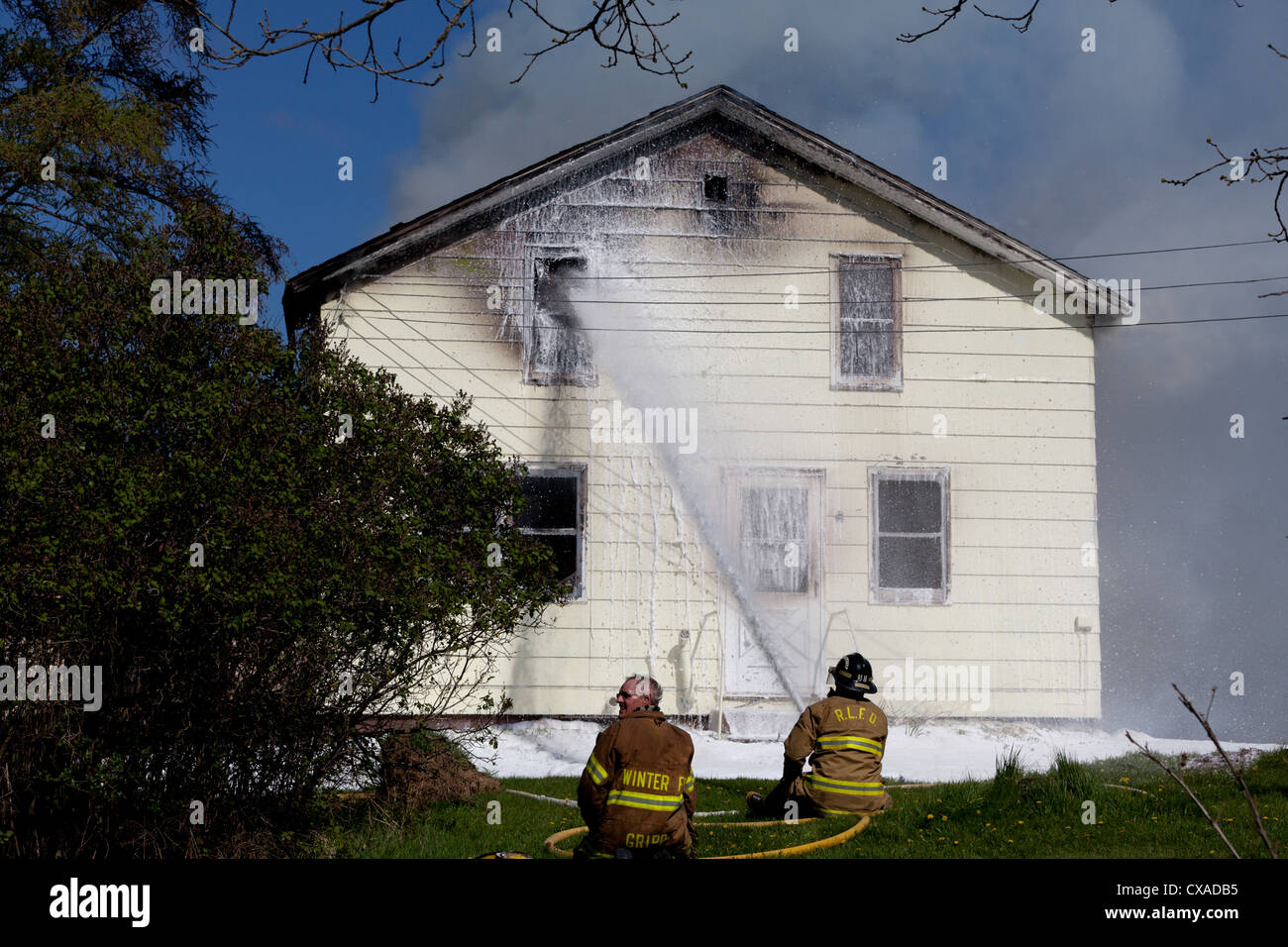 Volunteer firefighters fighting a house fire Stock Photo - Alamy