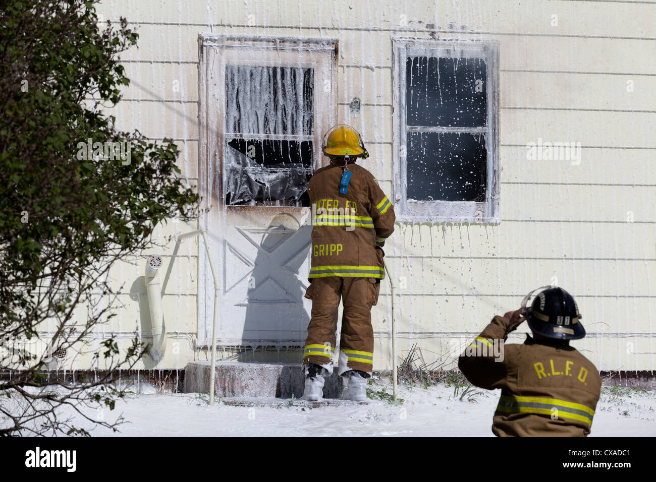 Volunteer firefighters fighting a house fire Stock Photo - Alamy