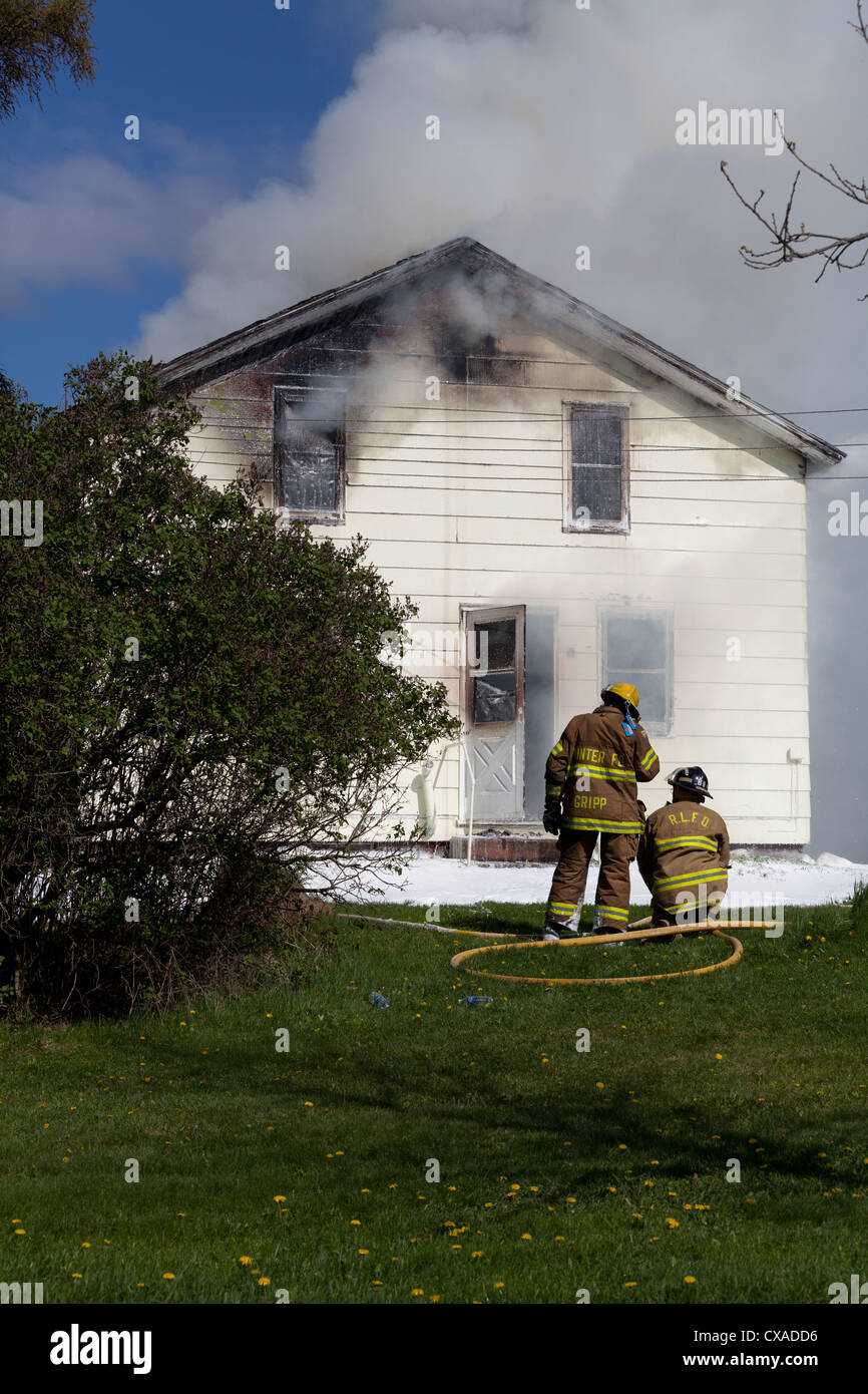 Volunteer firefighters fighting a house fire Stock Photo - Alamy