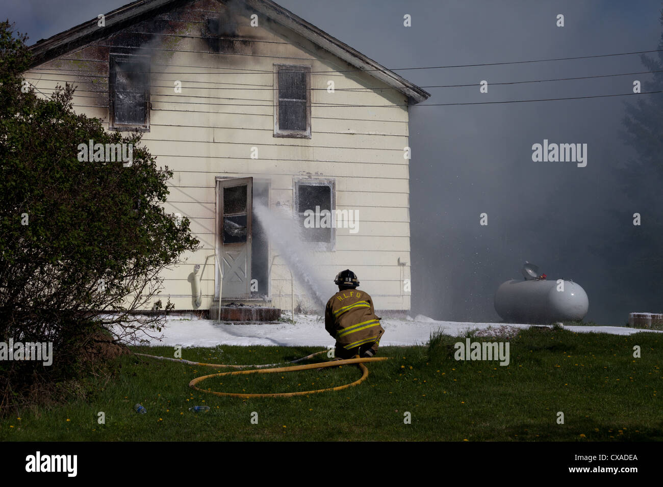 Volunteer firefighters fighting a house fire Stock Photo - Alamy