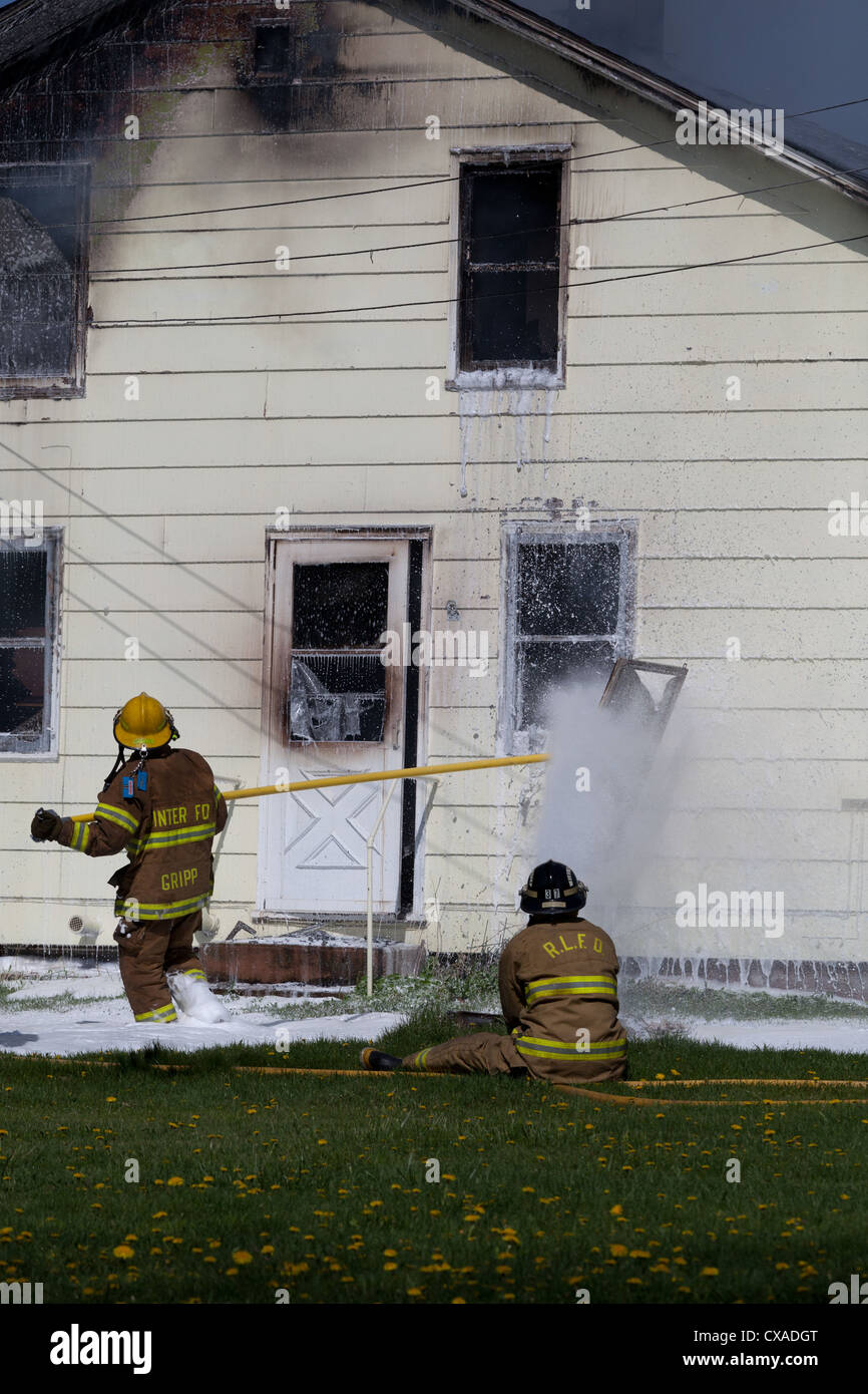Volunteer firefighters fighting a house fire Stock Photo - Alamy