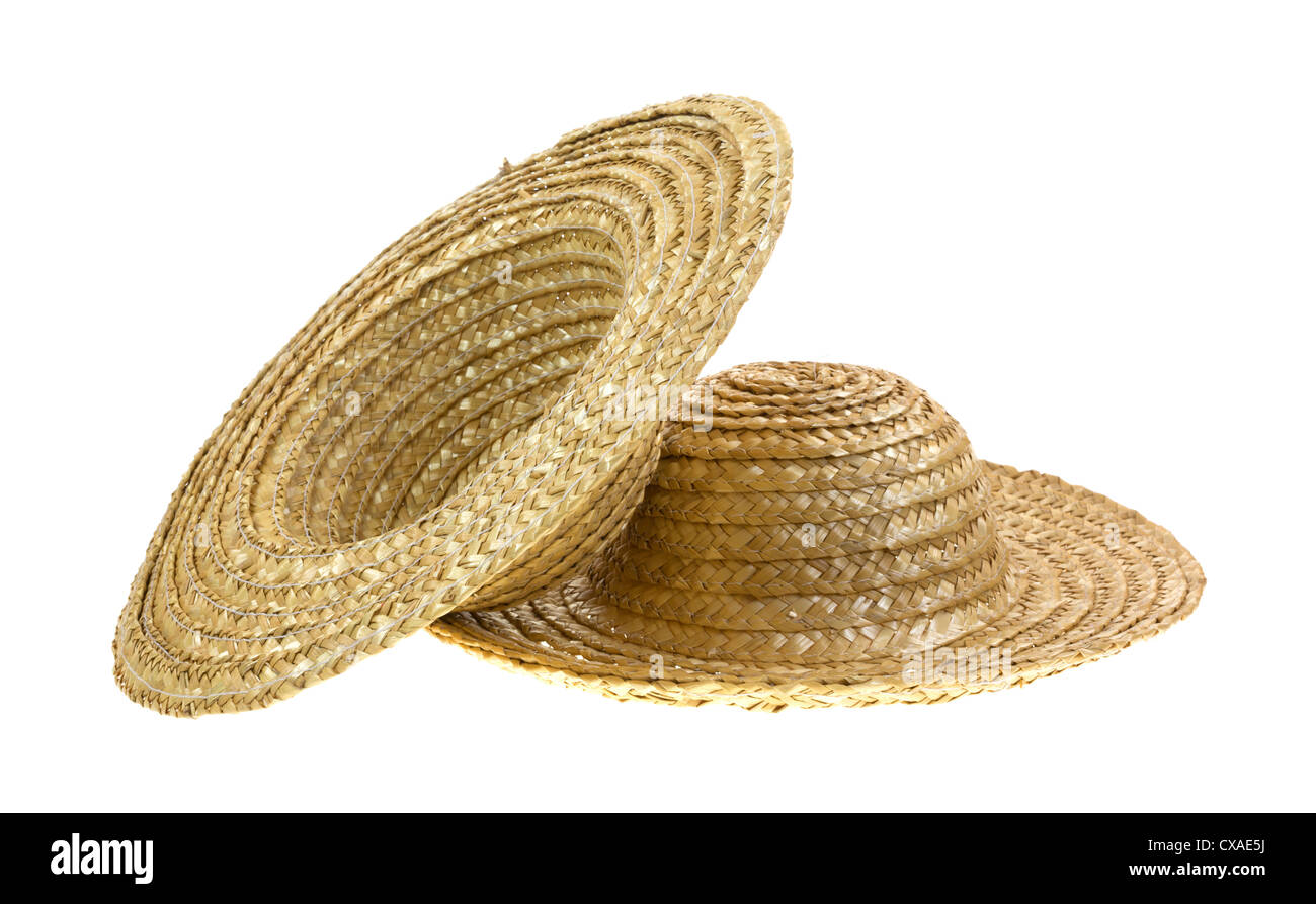 Two straw hats with one upside down atop another on a white background ...