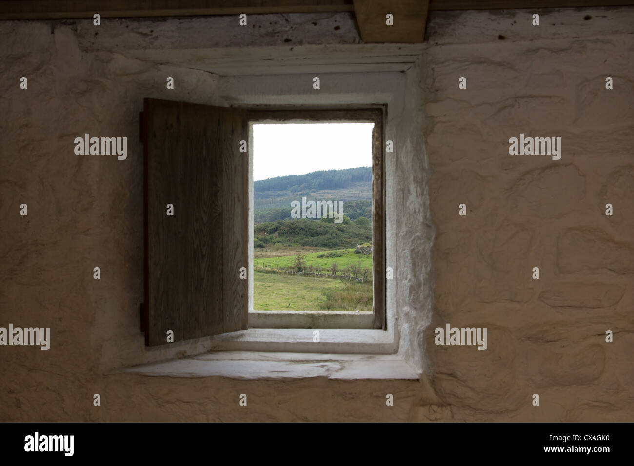 Rural view through wooden shuttered window of a mediaeval whitewashed ...