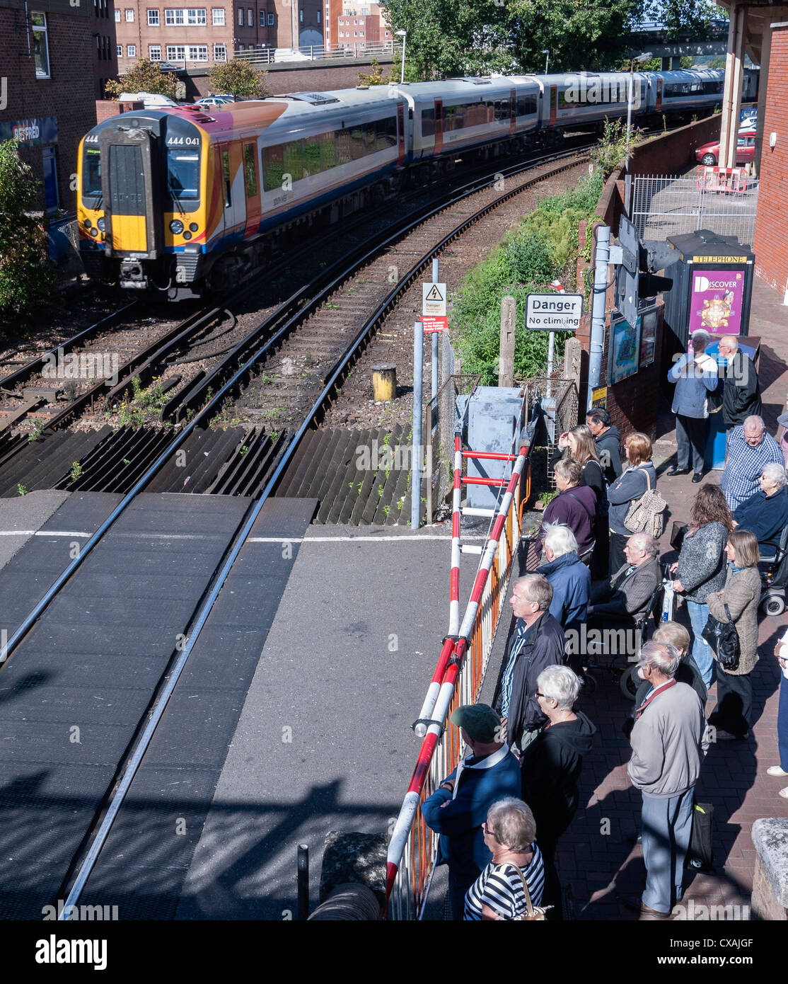 Poole Station, People at Railway Level Crossing Barrier with Train ...