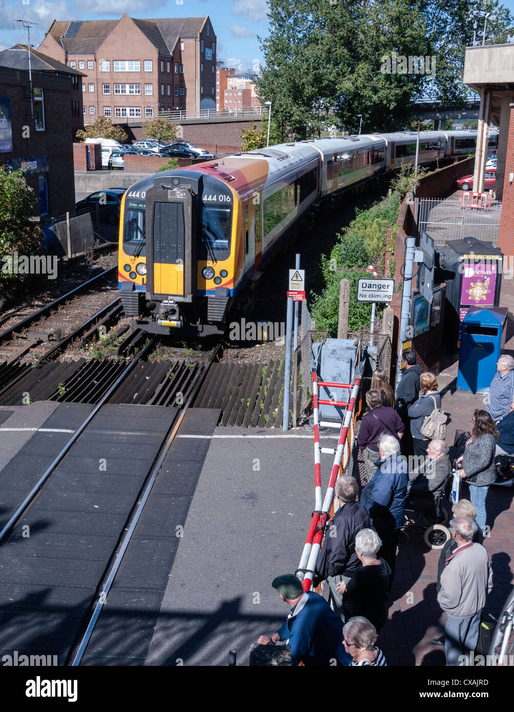 Poole Station, People at Railway Level Crossing Barrier with Train ...