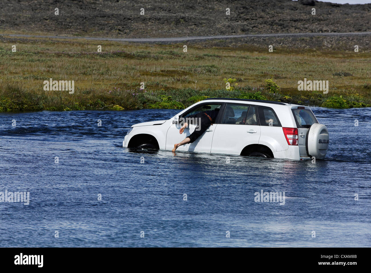 Man climbing through window of 4WD stuck in the Lindaá river, central ...