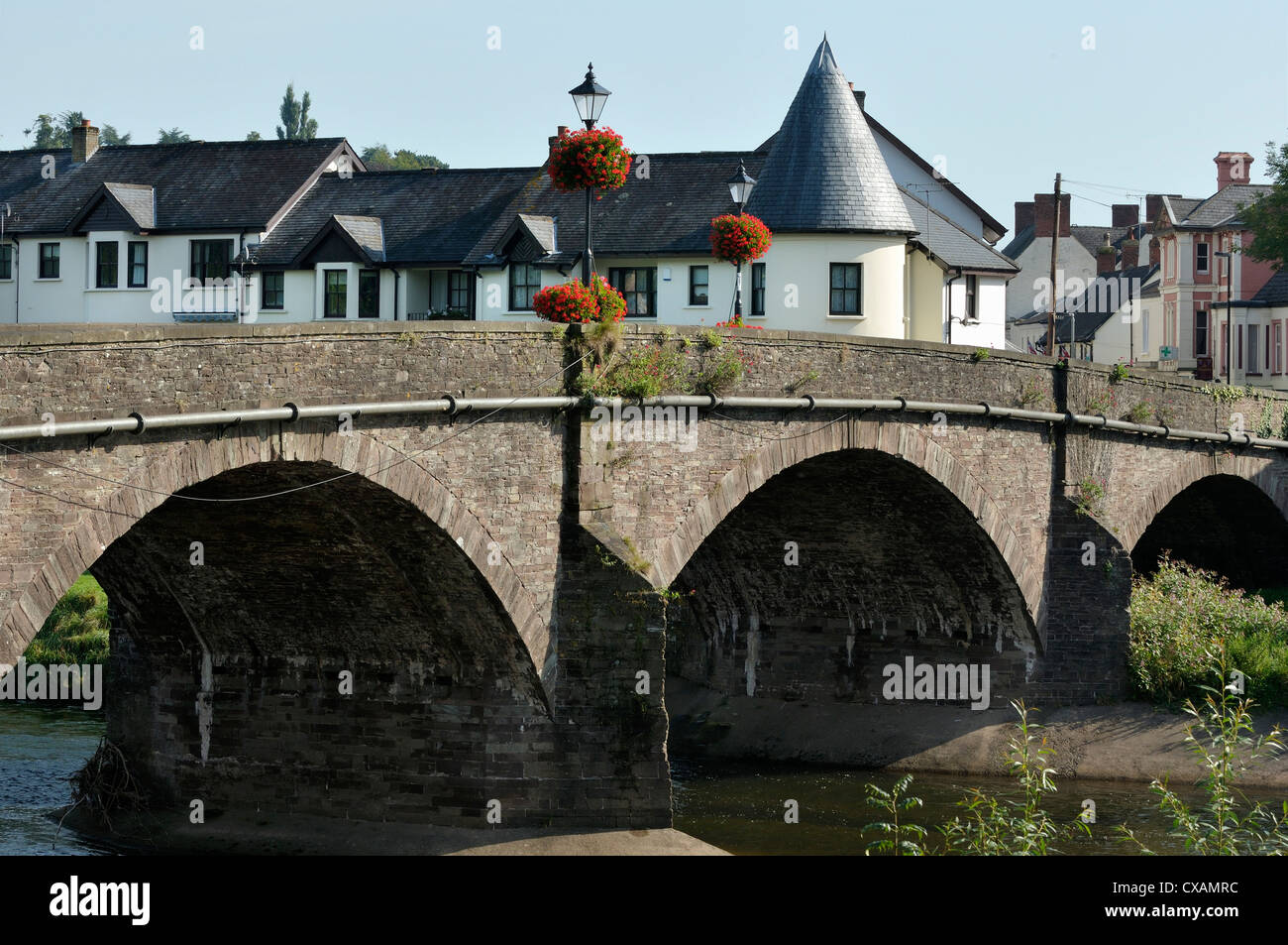Floral display on Usk Bridge with town houses behind. Usk ...