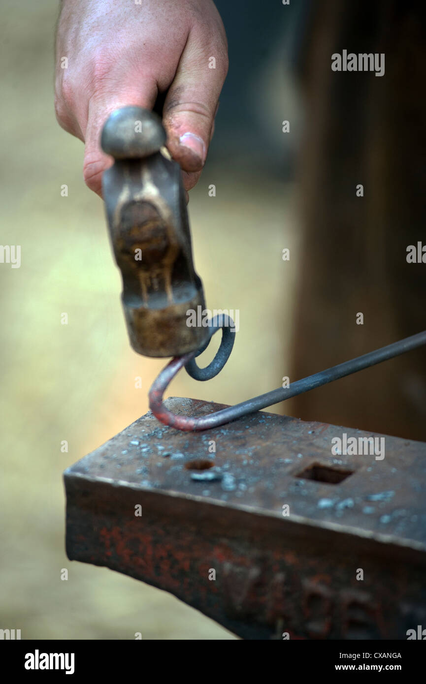 blacksmith forming a piece of hot metal Stock Photo - Alamy