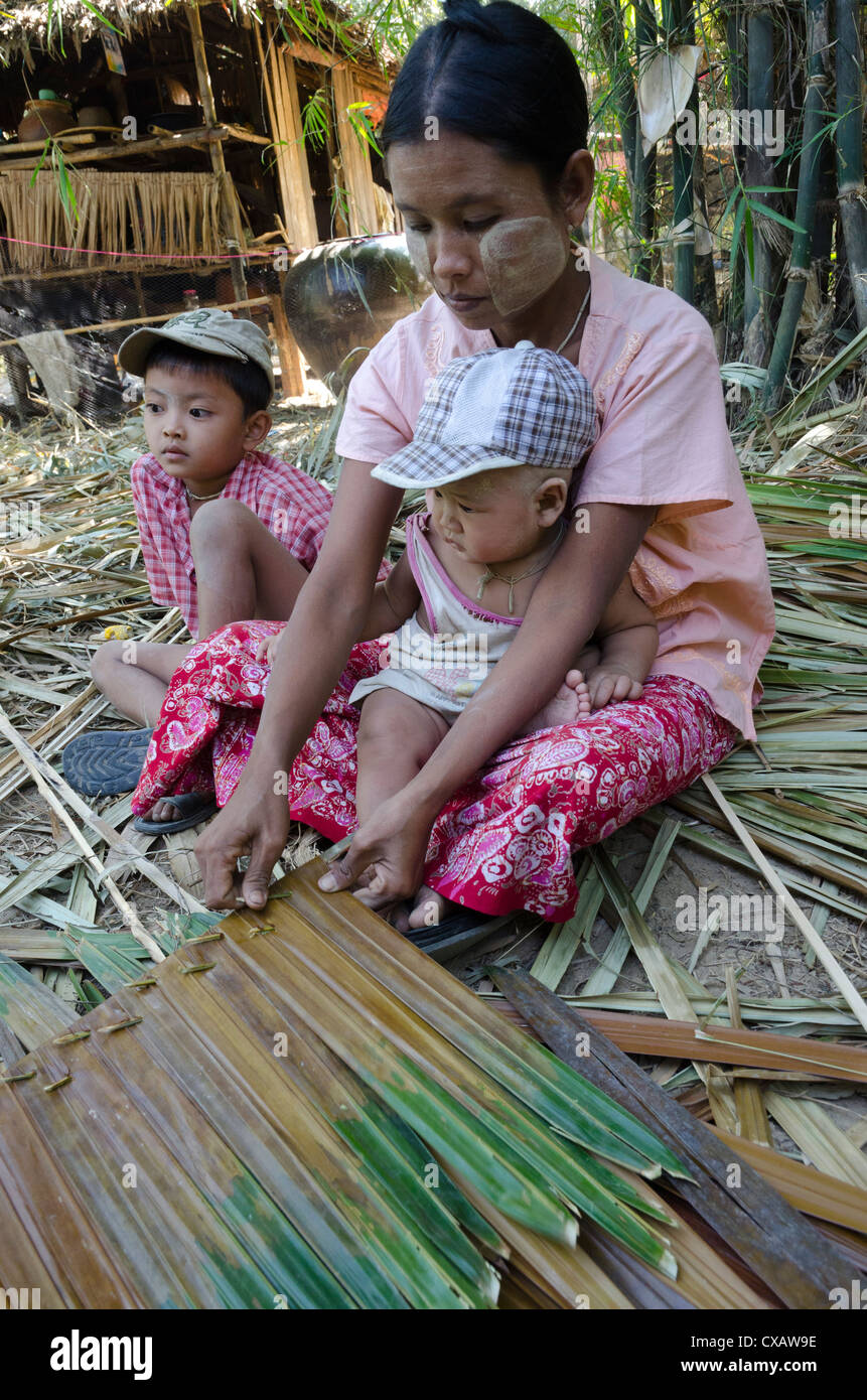 Portrait of a woman preparing leaves for roofing, Ye Saing Kone village ...