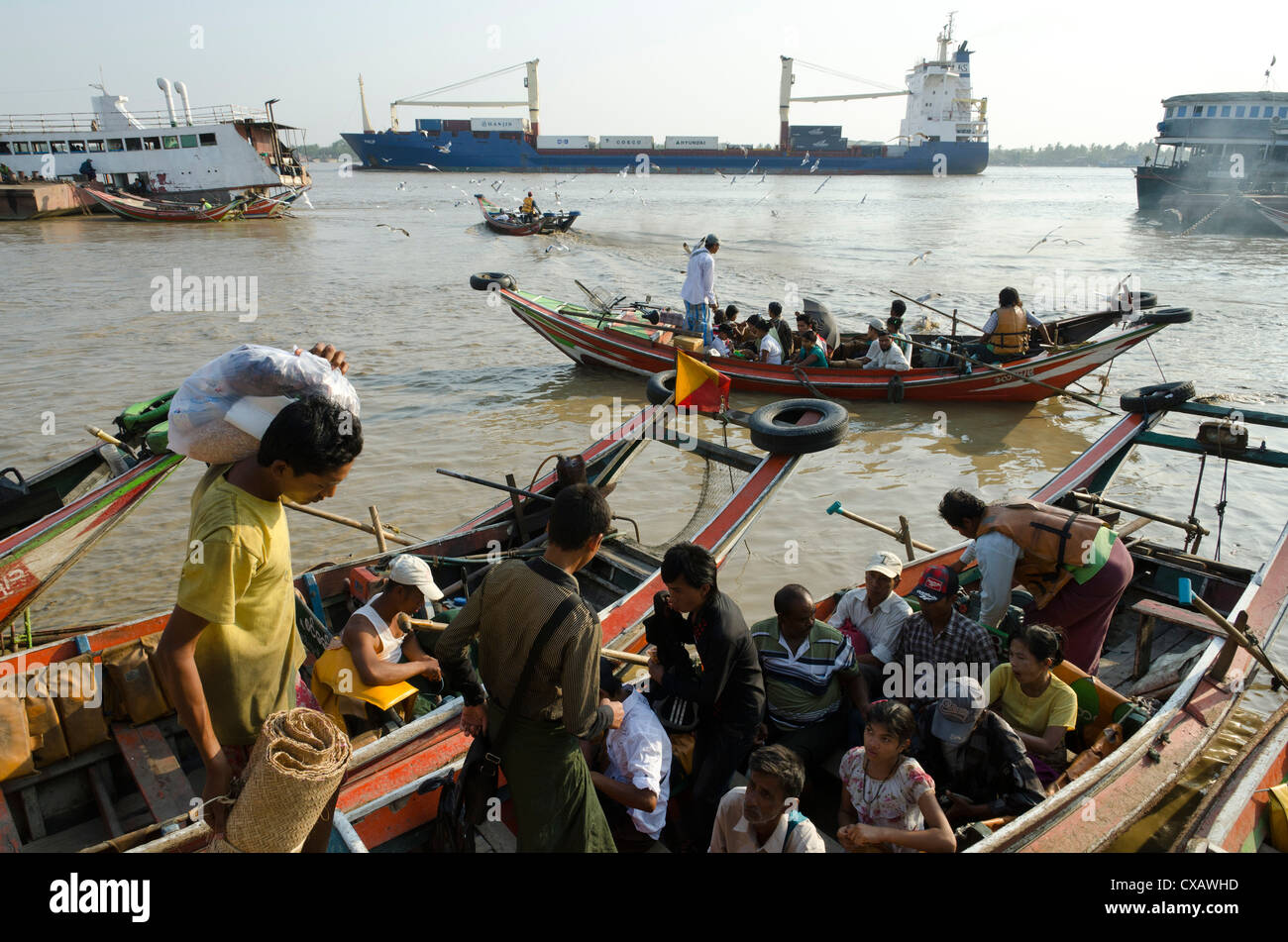 Passengers embarking on a small ferry boat across the river. Yangon ...