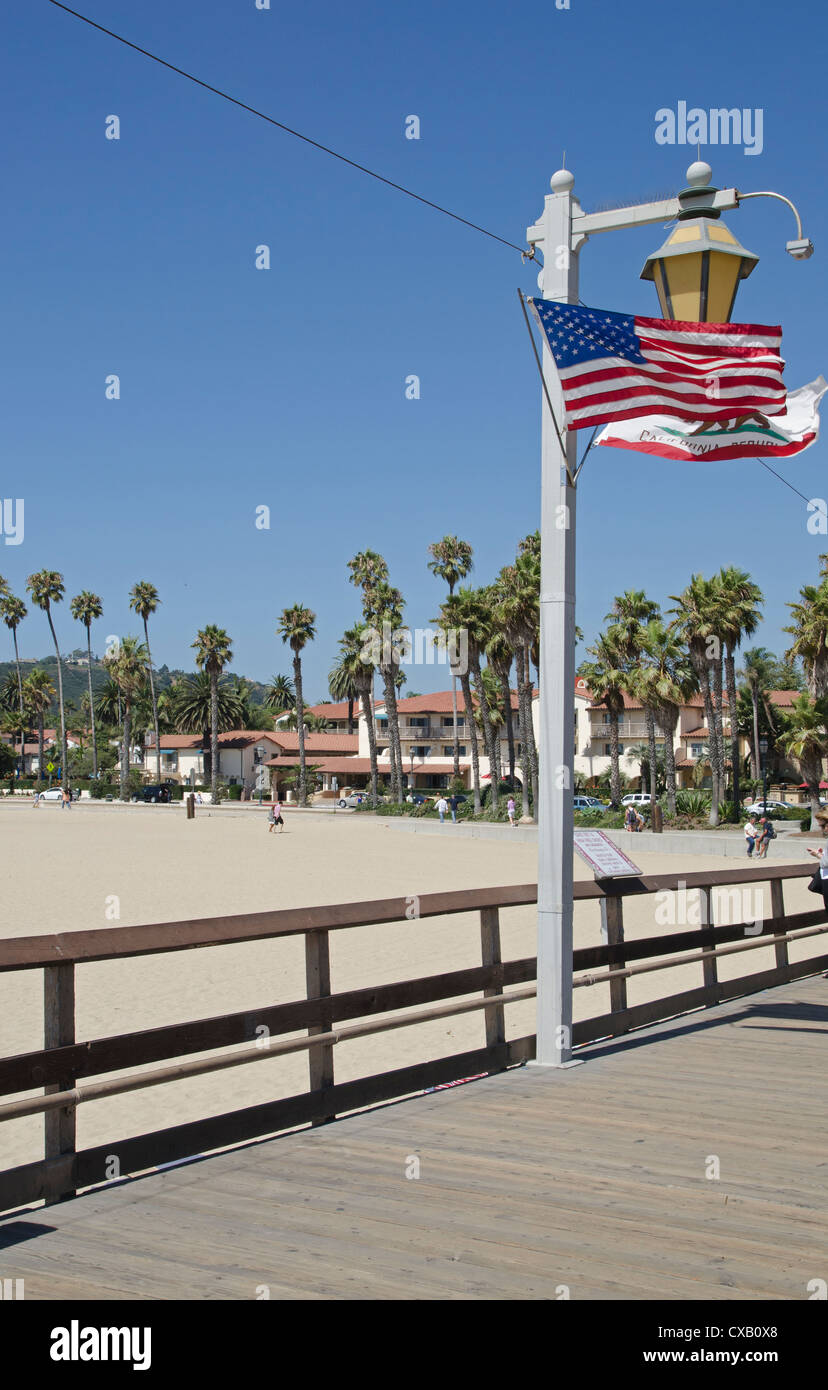 American flag waving on Santa Barbara pier overlooking beach ...