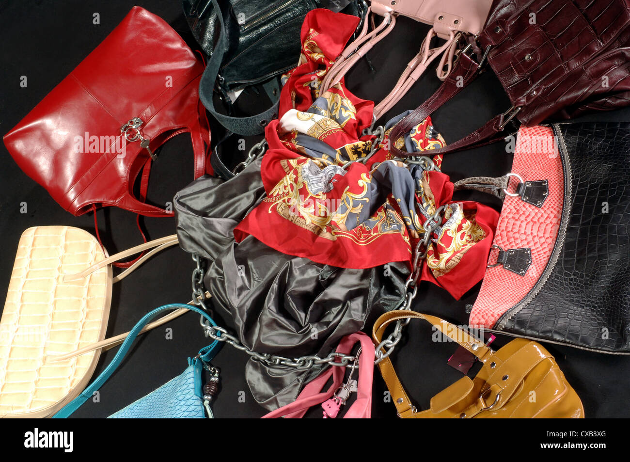 Women's handbags made of various materials on a black background Stock ...