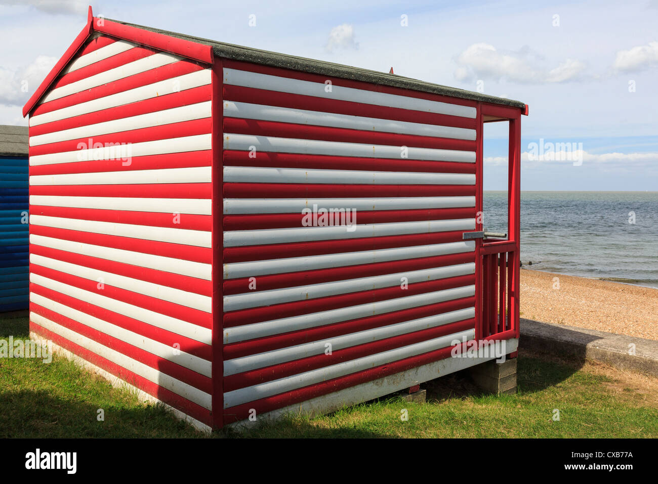 Colourful red and white striped beach hut overlooking the Thames ...