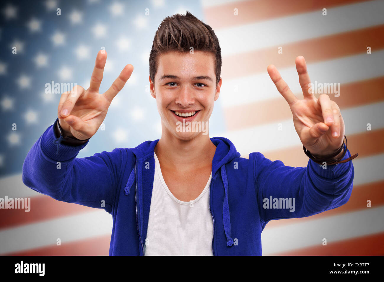 Portrait of a handsome young man gesturing victory symbol in front of ...