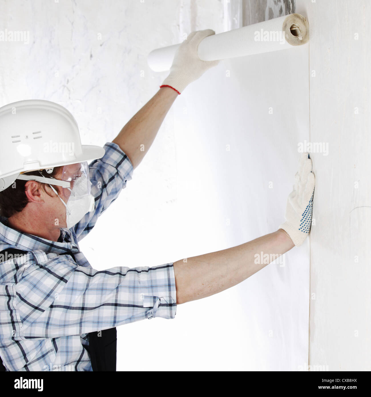 worker attaching wallpaper to wall Stock Photo - Alamy