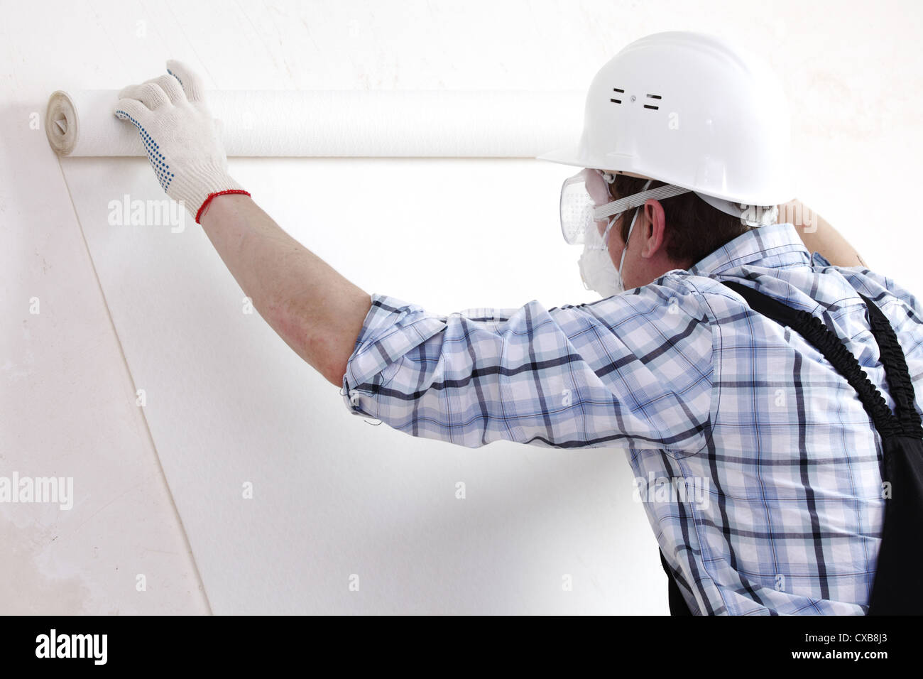 worker attaching wallpaper to wall Stock Photo - Alamy