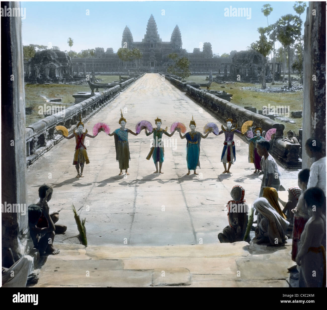 Colorized photo of temple dancers performing in a line for onlookers at ...