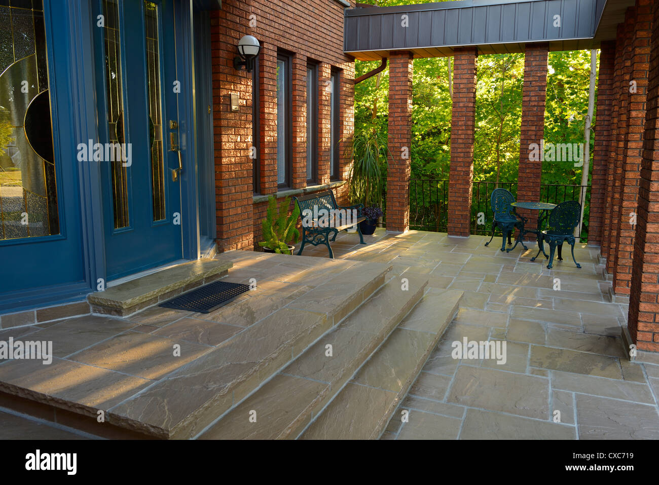 Front blue door and stone porch of red brick house with pillars at ...