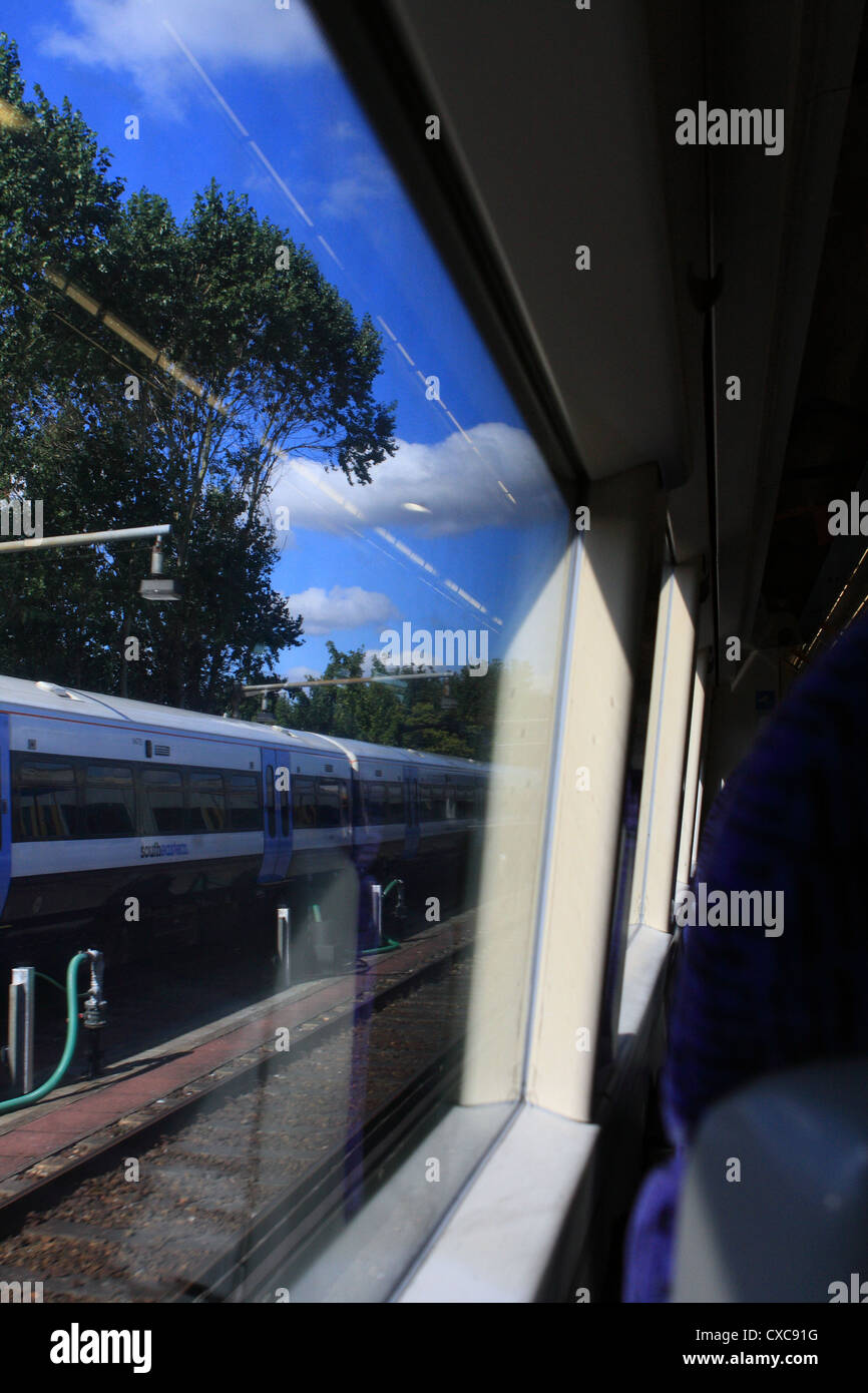 a view through a traveling train window of another train passing Stock ...