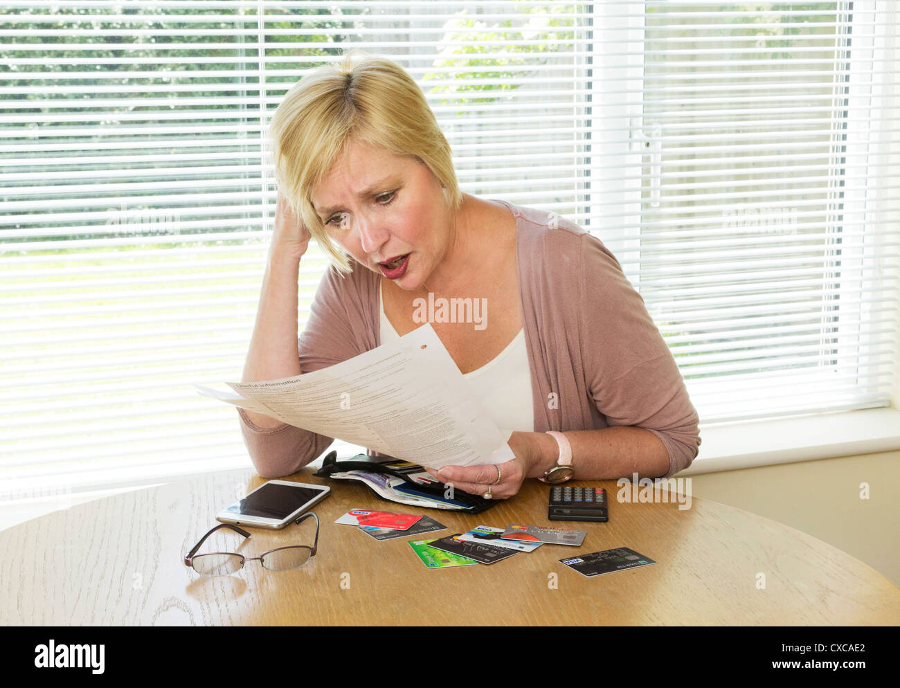 woman shocked at reading her credit card bill Stock Photo - Alamy